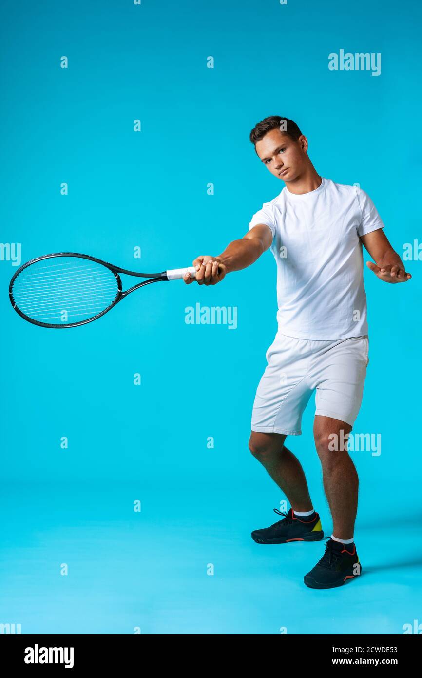 Full length studio portrait of a tennis player man on blue background ...