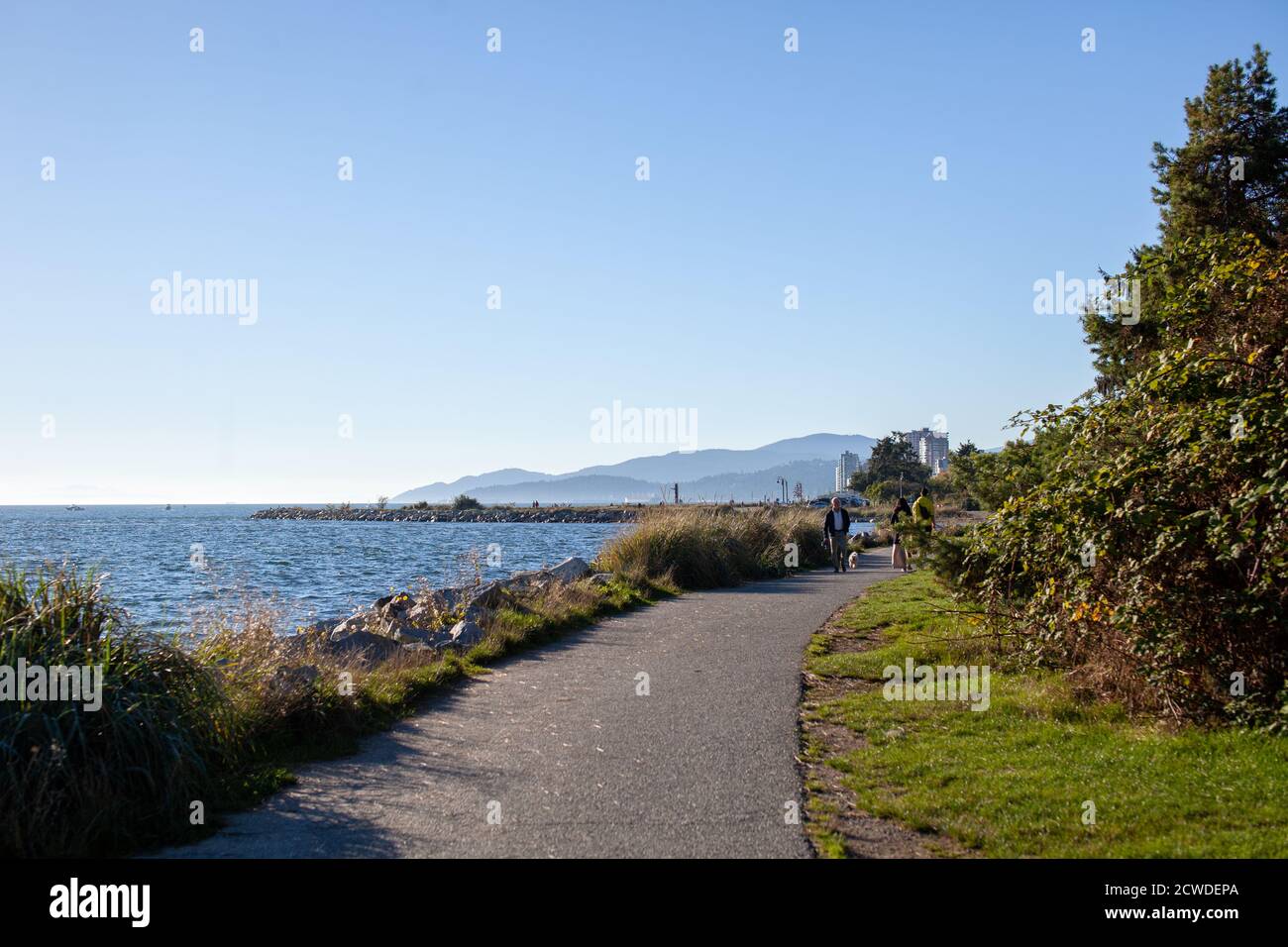 People enjoying the walking trails at Ambleside Beach in West Vancouver ...
