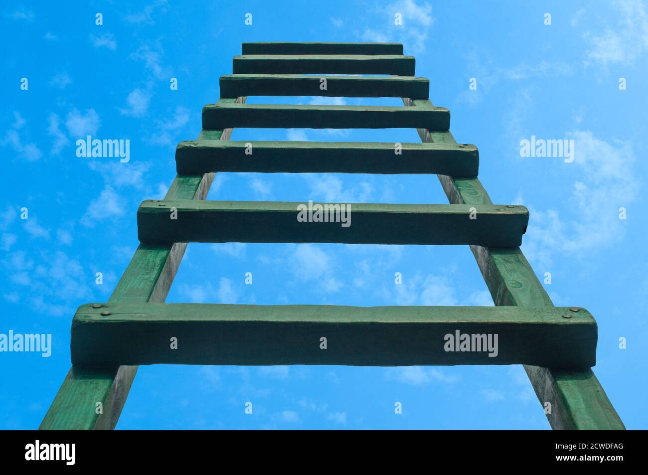 Reaching For Green Ladder Leading To A Blue Sky Stock Photo - Alamy