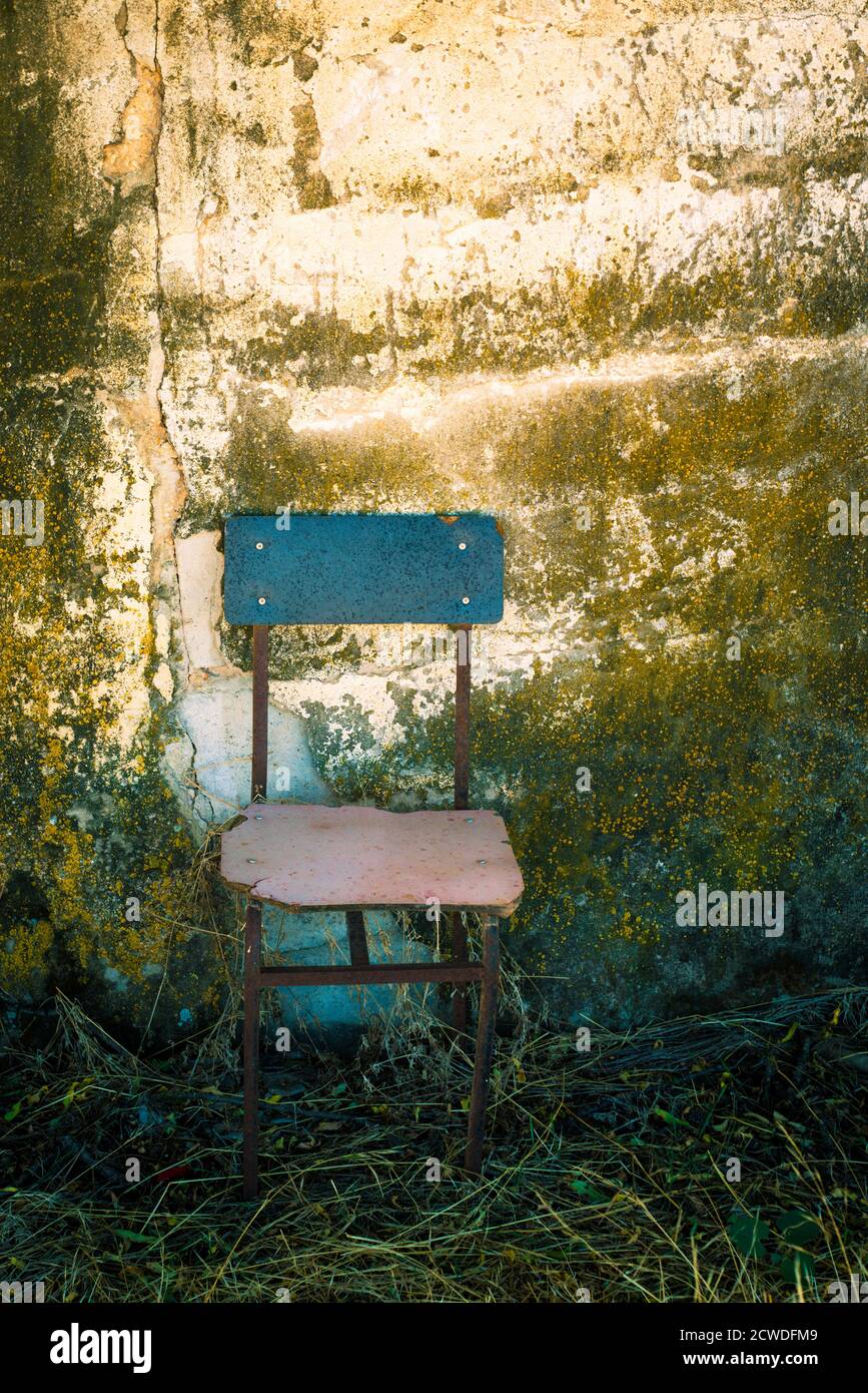 Old wooden rusty and old chair leaned on the wall on the grass Stock ...