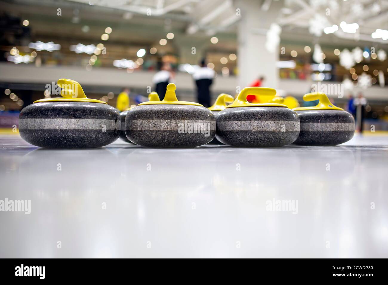 The curling stone or rock is made of granite with yellow handles lie ...