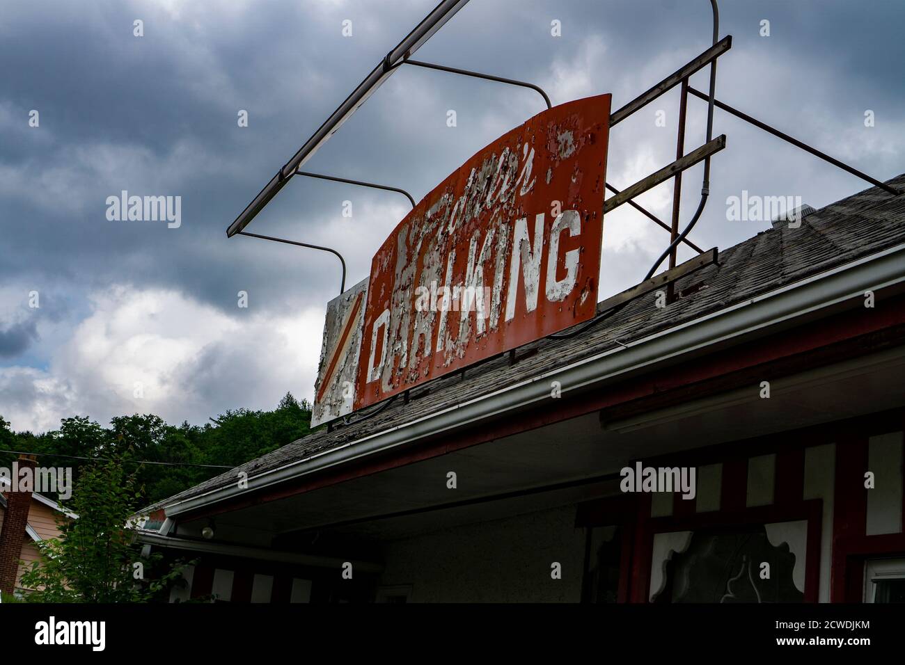 Old, rusty, broken store signage in an abandoned shop. Stormy clouds in ...