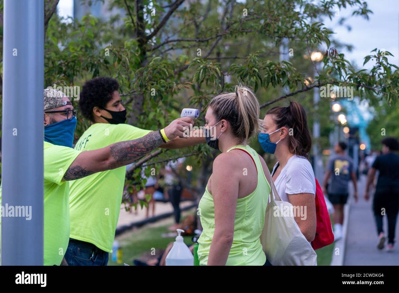 People getting their temperatures taken as they enter to join a ...