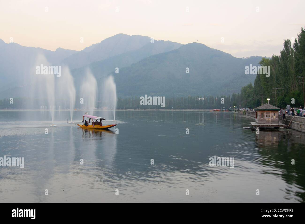 Fountains over the Dal Lake with mountains in the background, at dusk ...