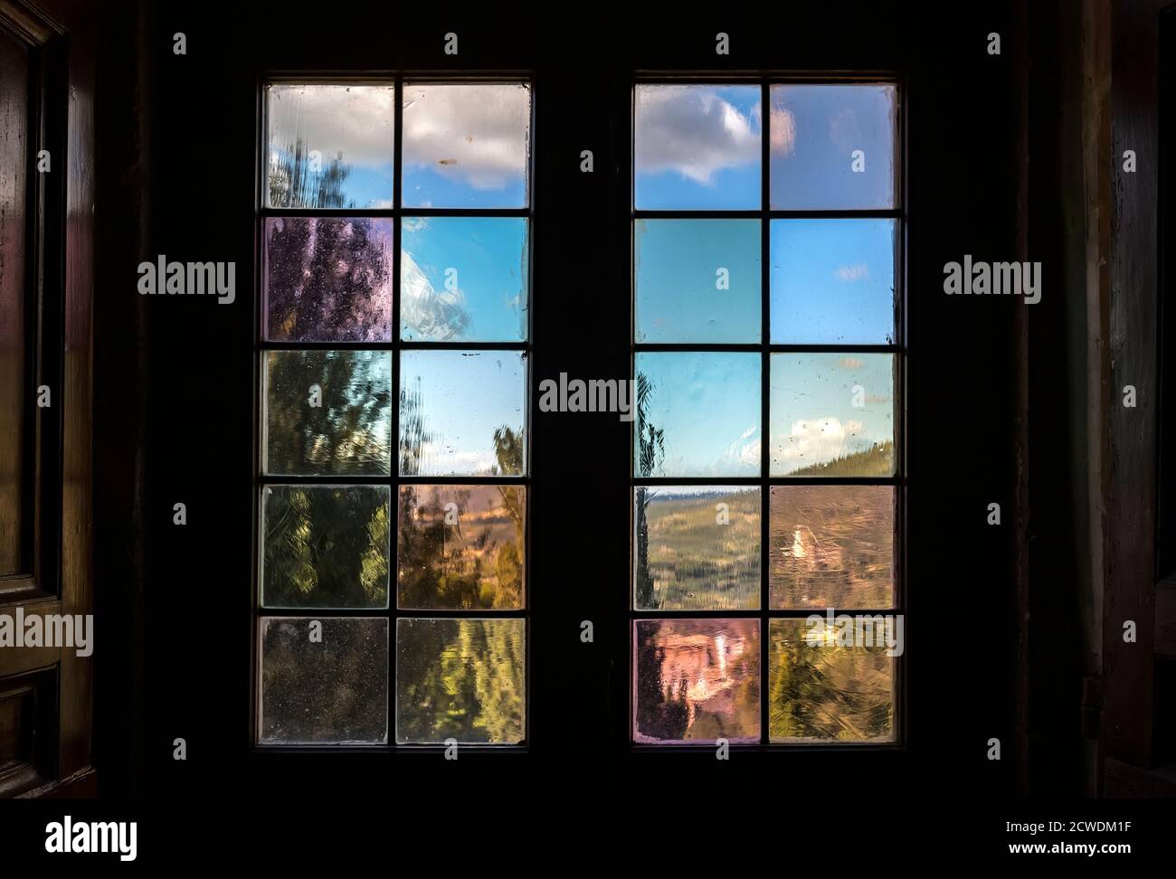 Old wooden window with shutters. A window with multi-colored glass ...