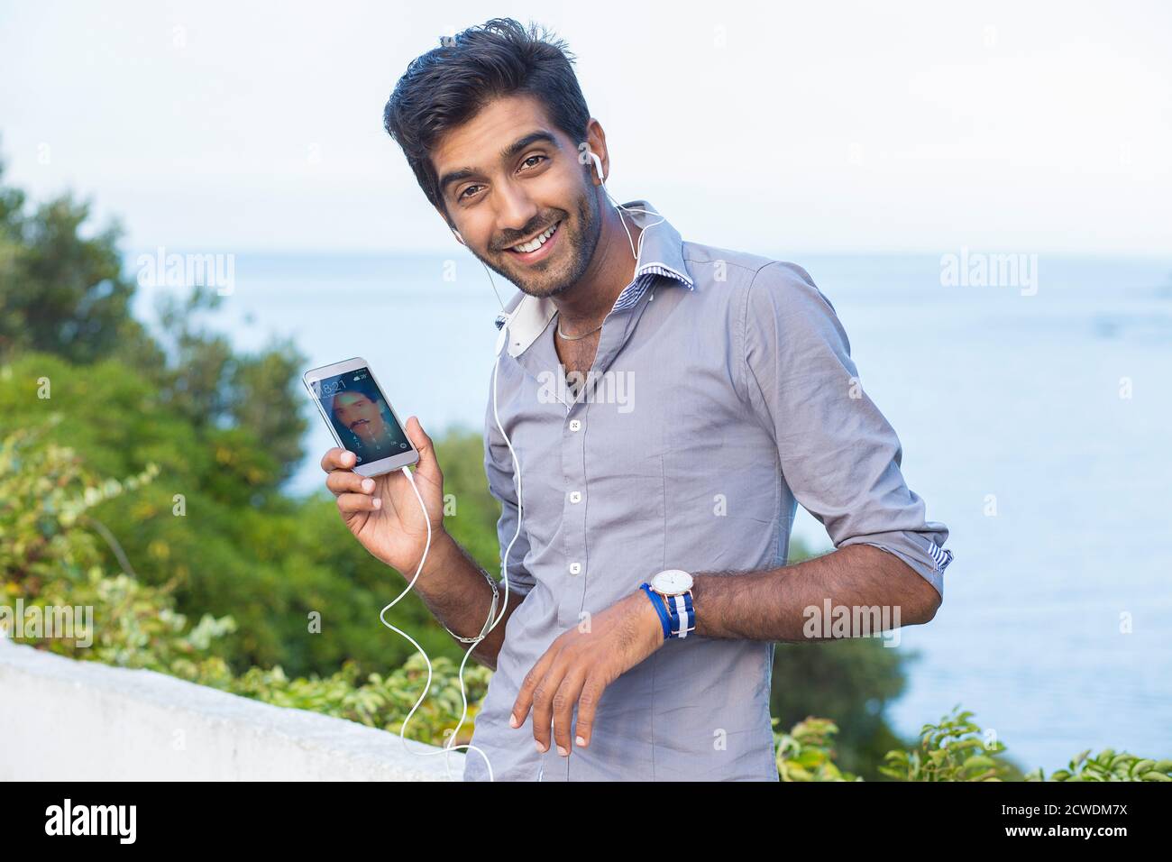 Portrait closeup of man showing phone screen smiling happy. Mixed race ...