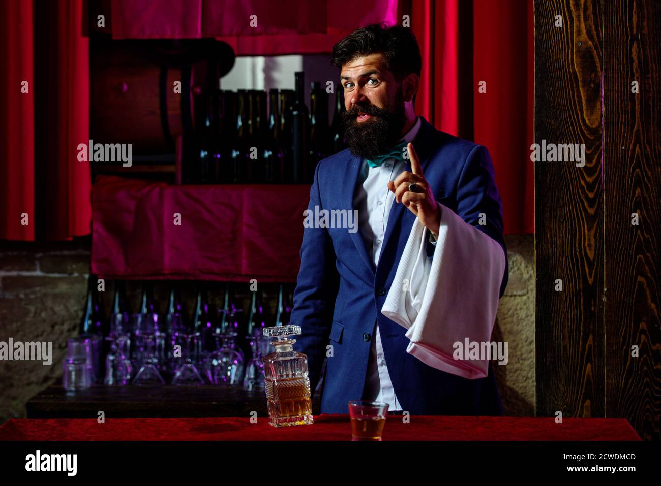 Handsome bearded barman leaning on bar counter. Expert bar man is ...