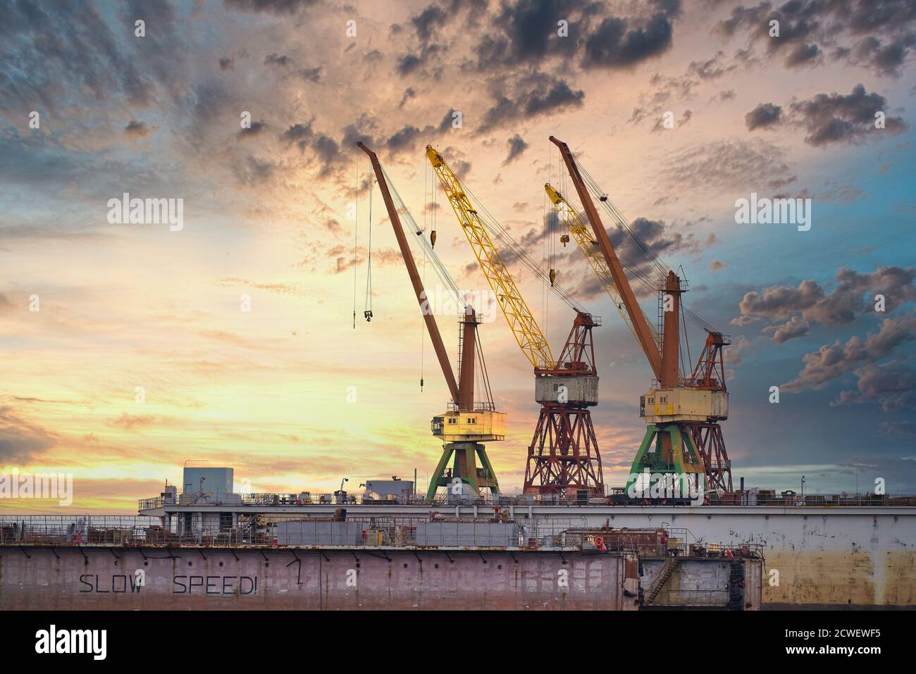 Massive blue, orange and yellow cranes in harbour Stock Photo - Alamy
