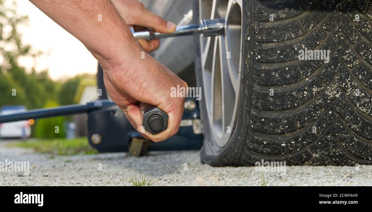 Man changing wheel. tire changer changing flat car tire. Help on road ...