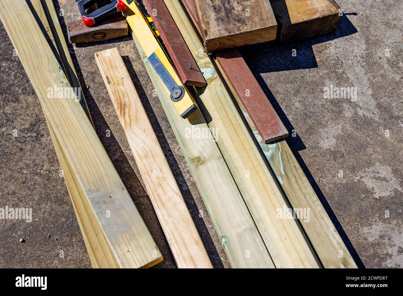 pile of timber beams on concrete to be used for landscaping work ...