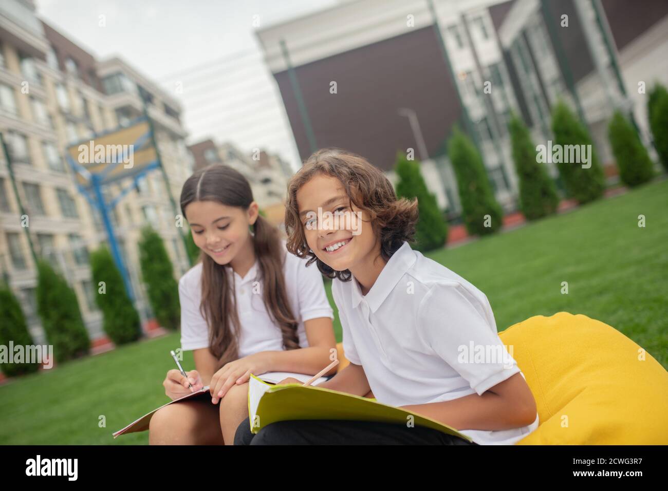 Boy and girl working together on a project and feeling good Stock Photo ...