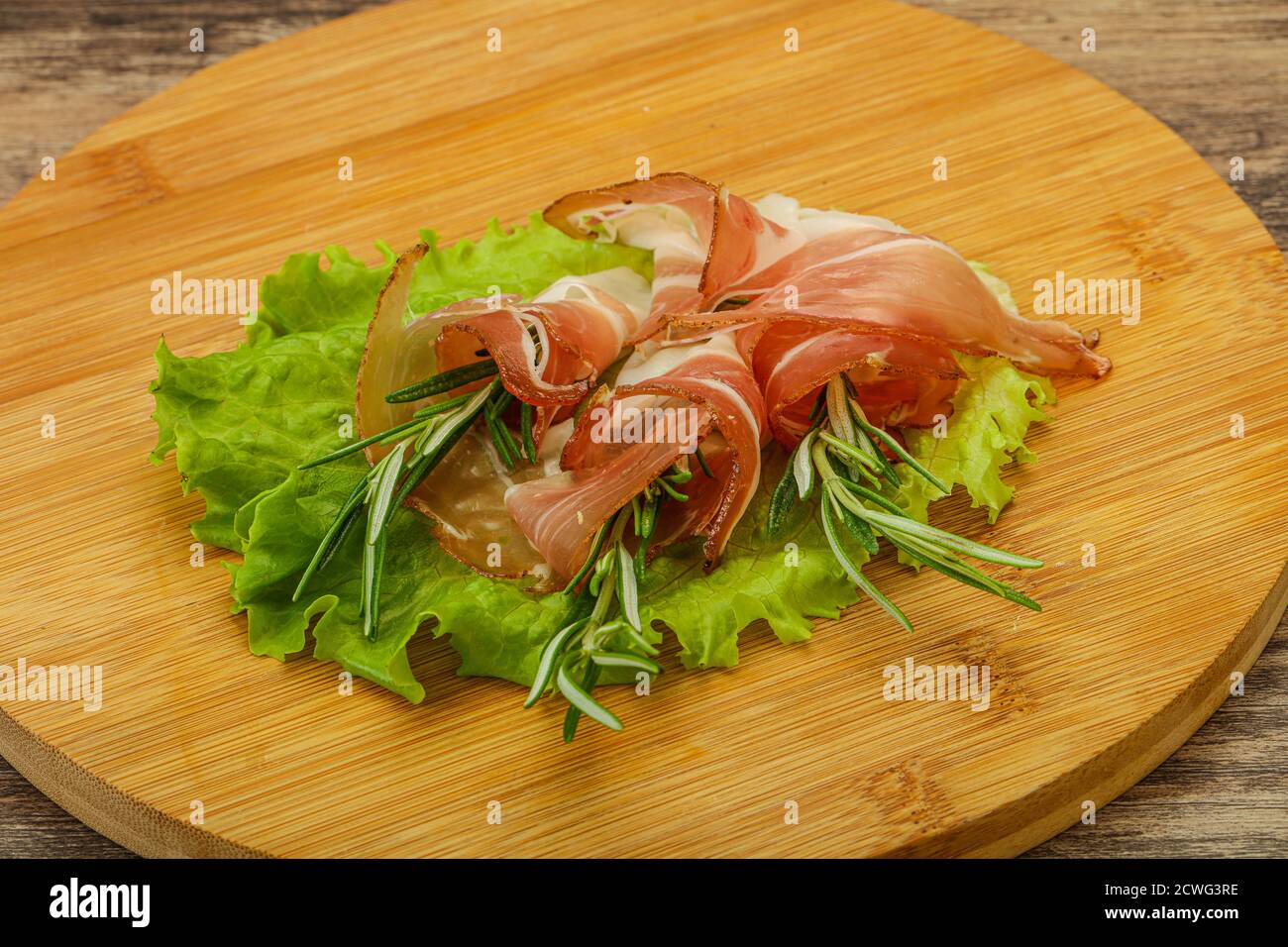 Sliced pork Jamon meat with rosemary Stock Photo - Alamy