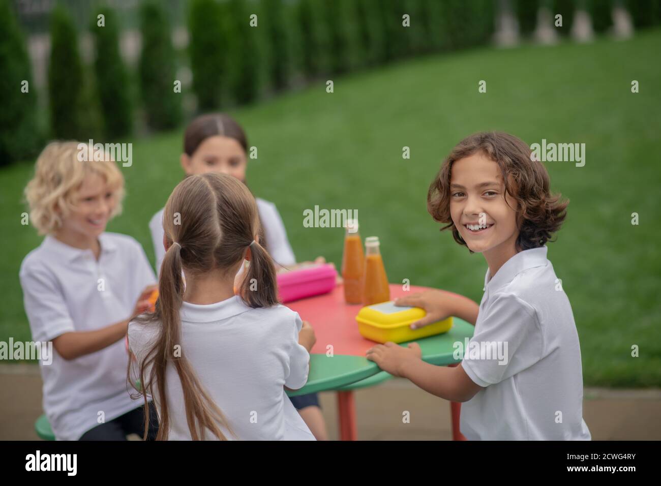 Children having lunch together and looking cheerful Stock Photo - Alamy