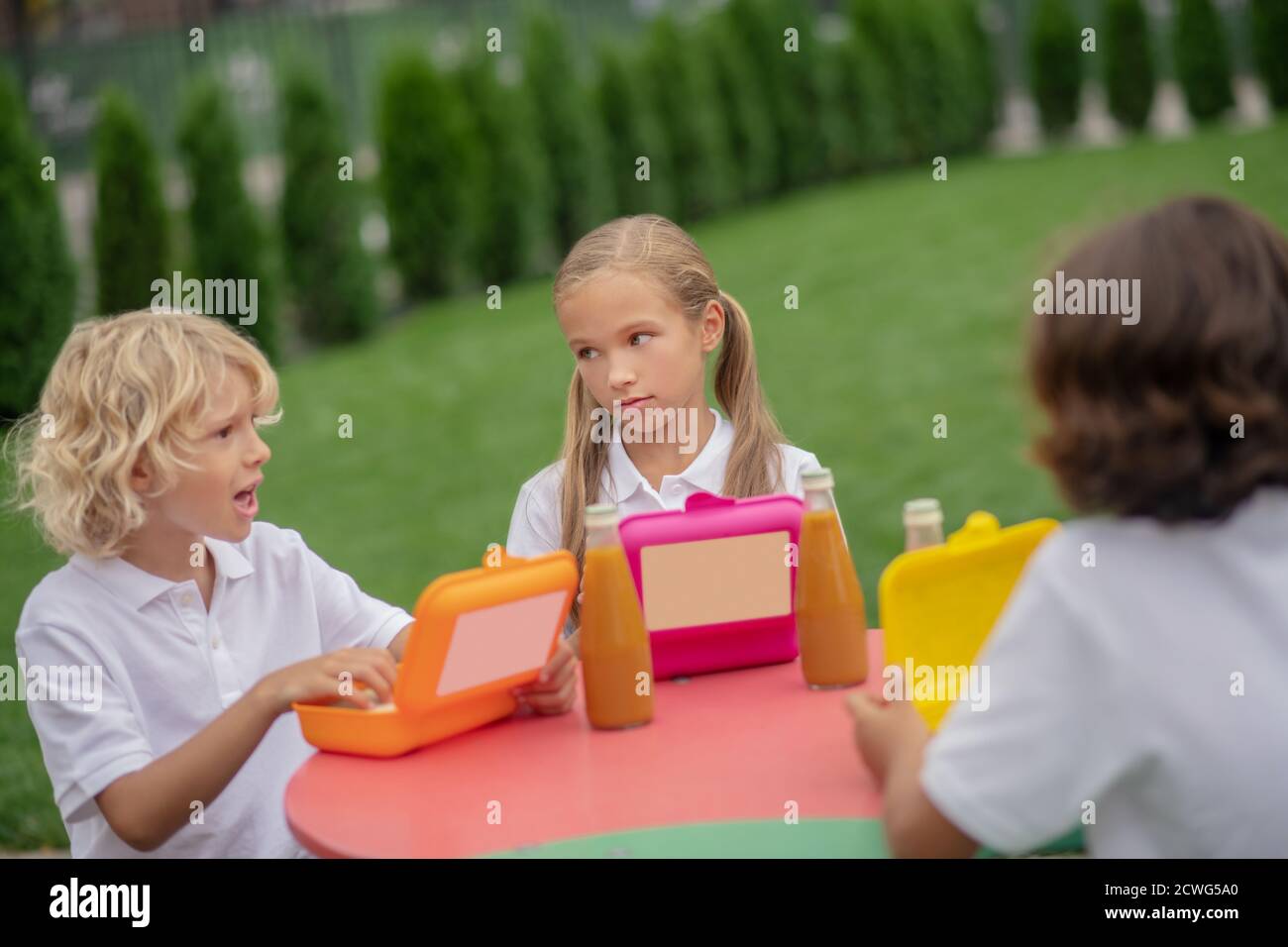 Children having lunch together and talking seriously Stock Photo - Alamy