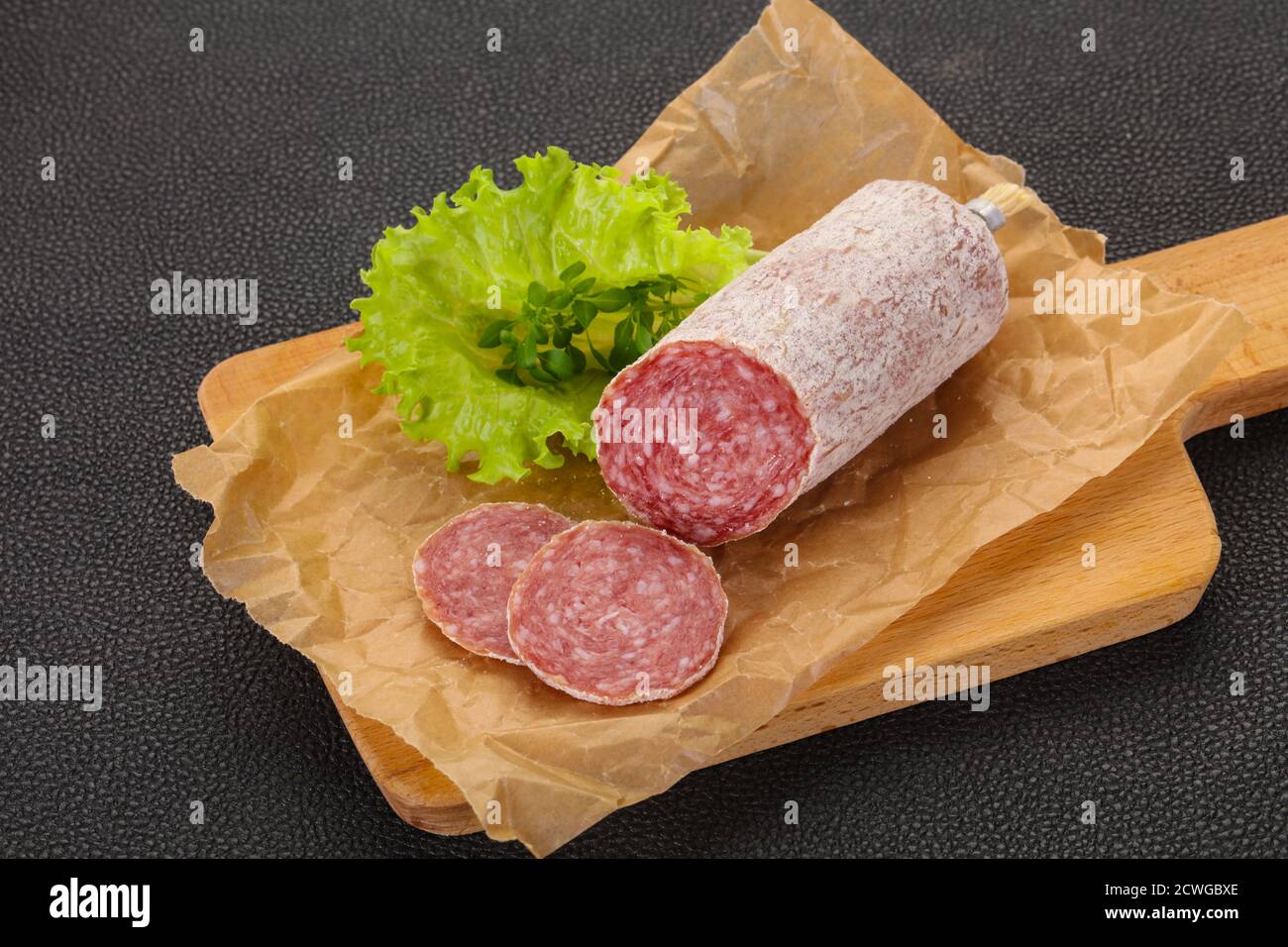 Italian dry Saliami pork sausage served salad leaves Stock Photo - Alamy