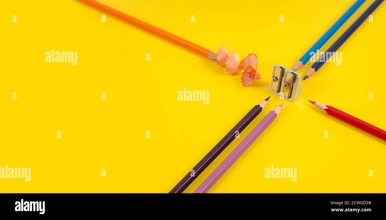 Some colored pencils of different colors and a pencil sharpener and ...