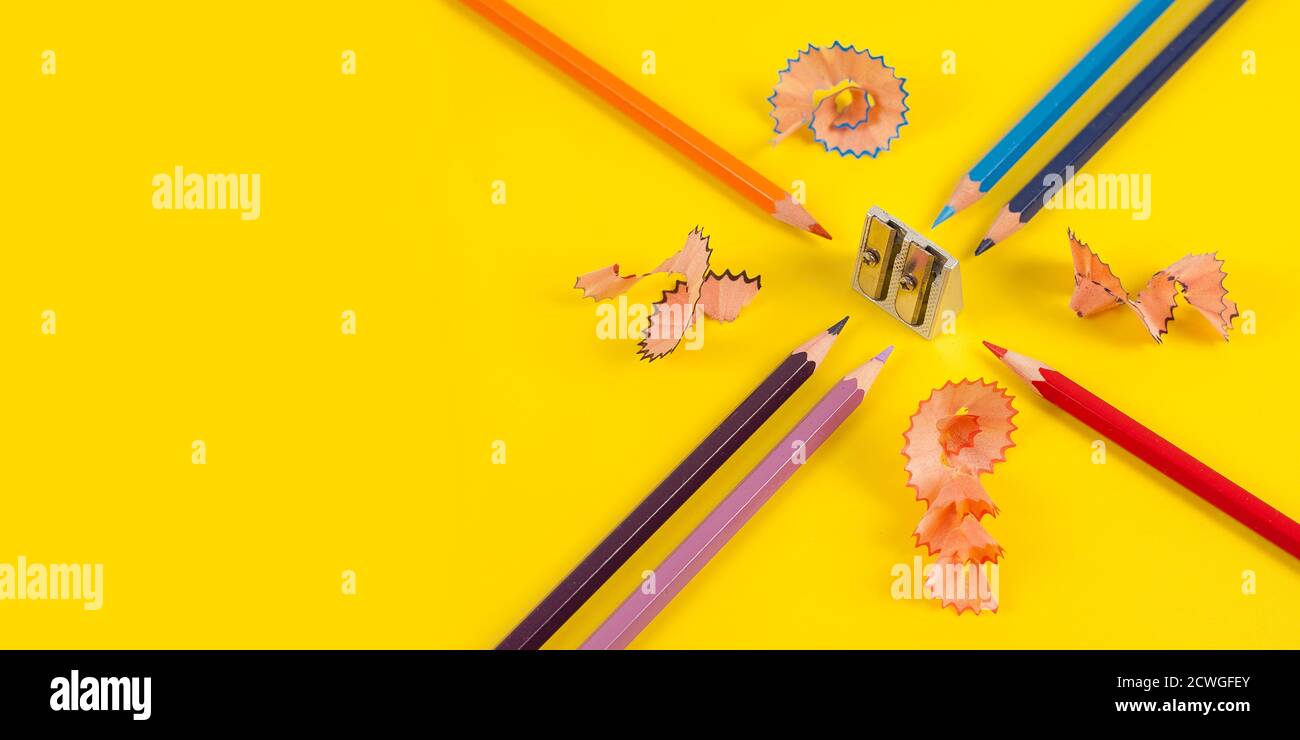 Some colored pencils of different colors and a pencil sharpener and ...