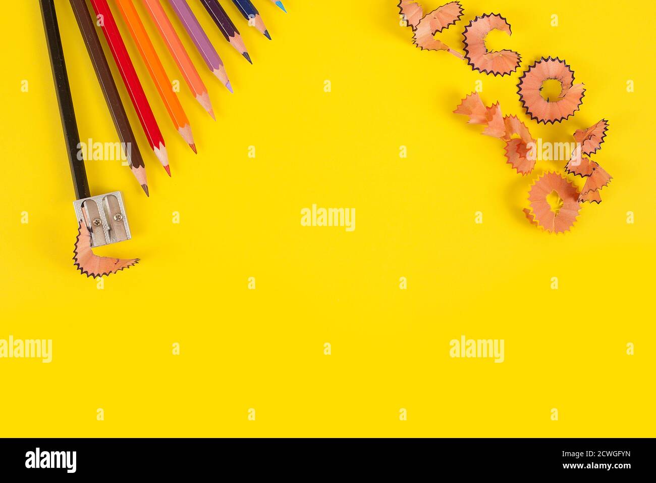 Some colored pencils of different colors and a pencil sharpener and ...