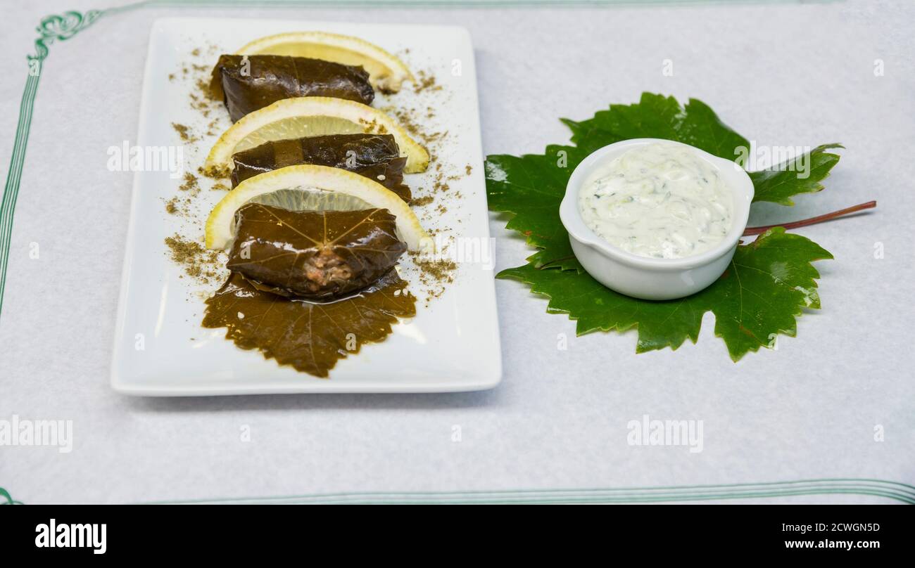 Plate of dolma with lemon. Dolma - stuffed grape leaves with rice and ...