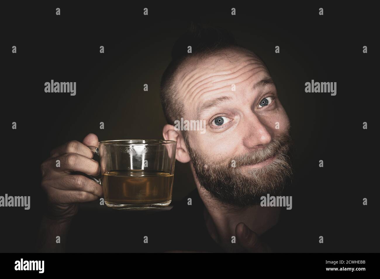 A friendly guy smiles at the camera and offers tea Stock Photo - Alamy