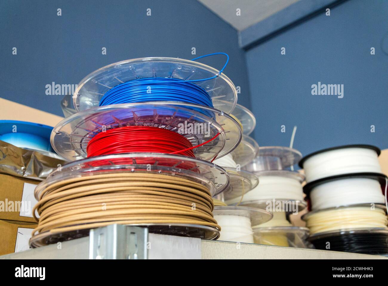 Stacks of 3d printing filament in different colors lying on metal shelf ...