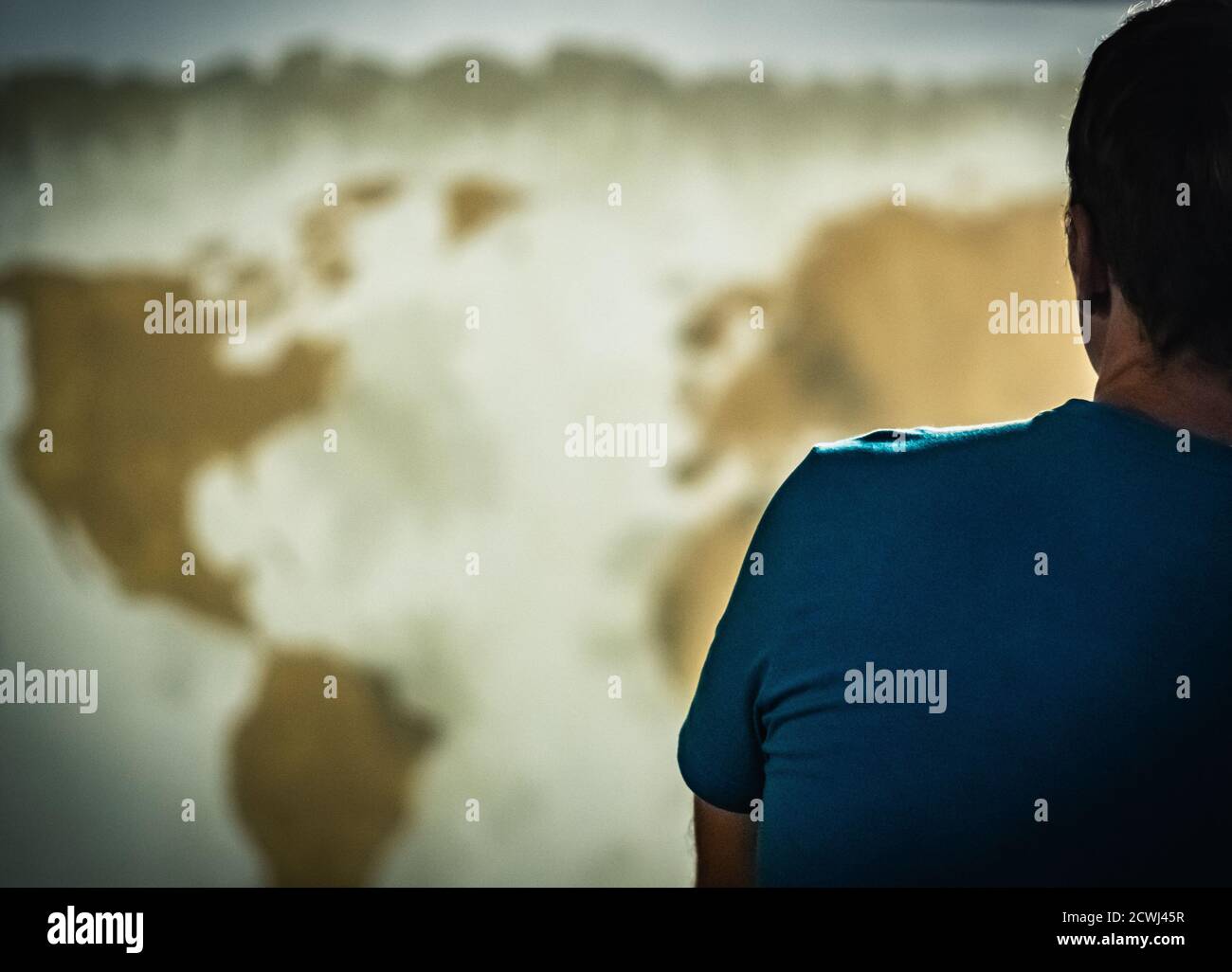 Back view Man looking far away wall world map background. Global ...