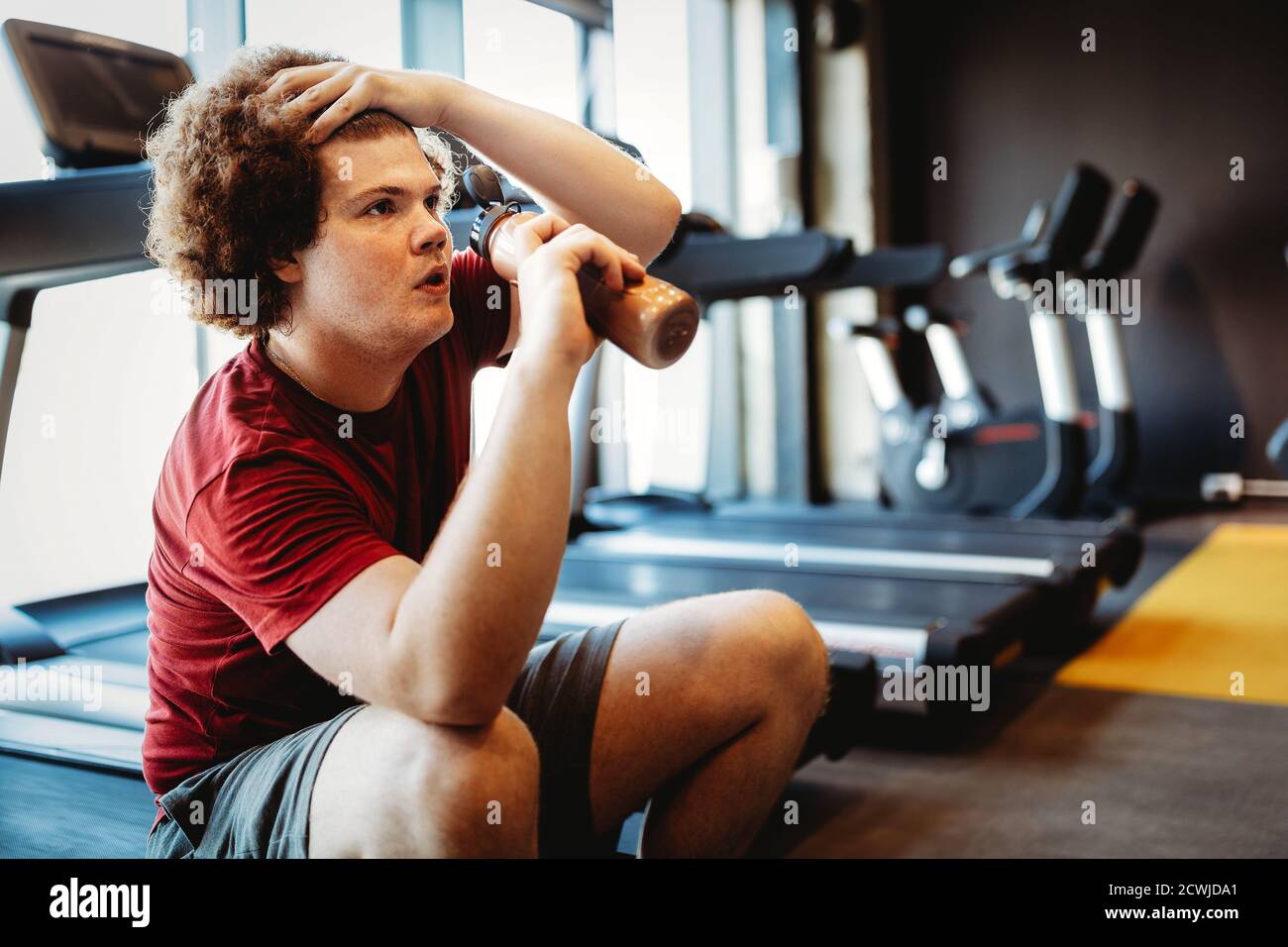 Tired fat man thinking over weight problems, desire to lose weight, gym ...