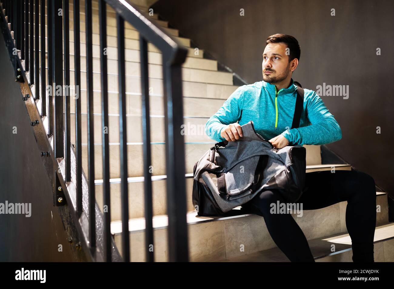Happy fit man relaxing in the gym after strength exercises for ...