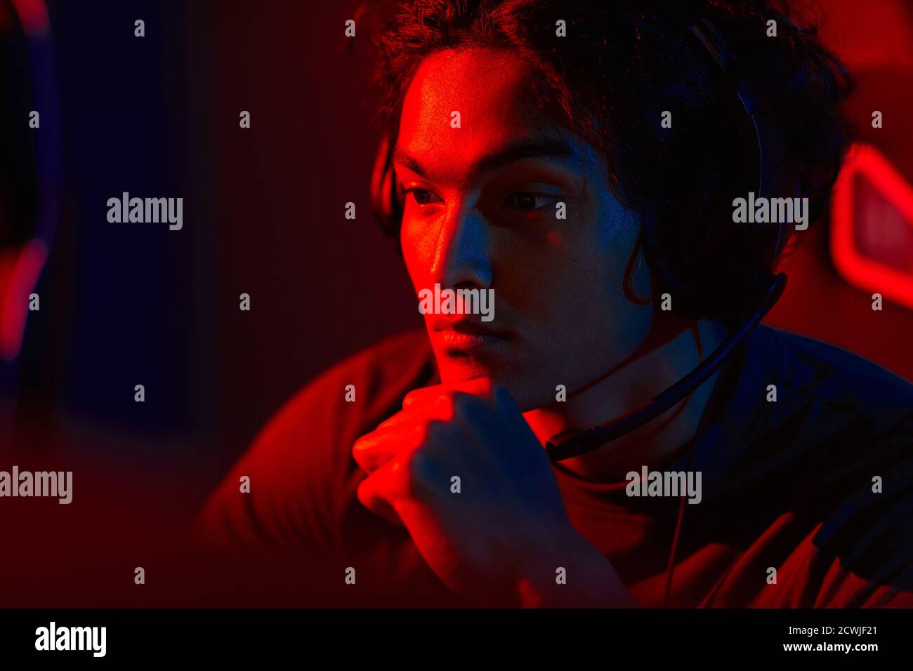 Close-up of hacker in headphones concentrating on his work sitting in ...