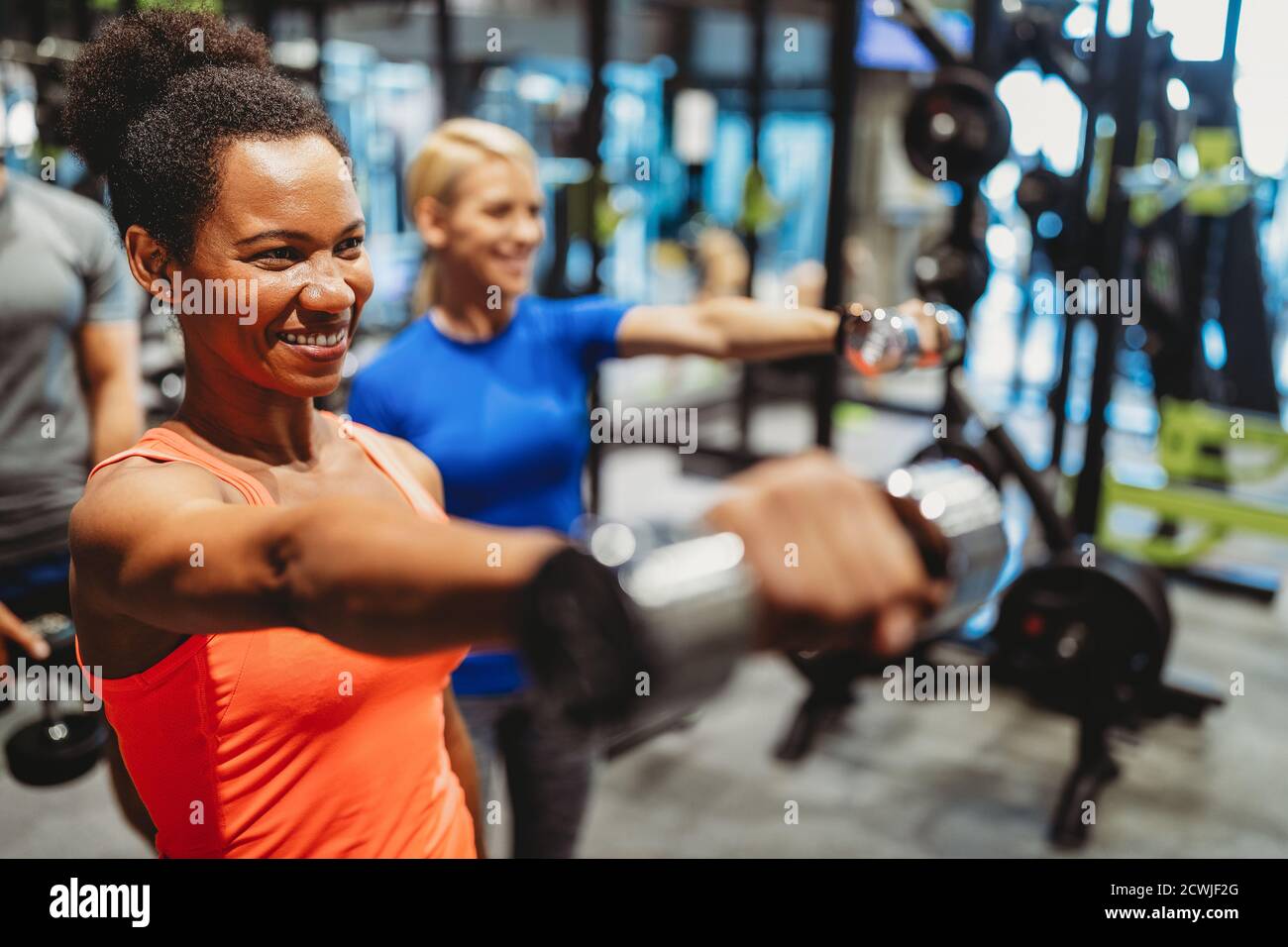 Group of young happy fit people doing exercises in gym Stock Photo - Alamy