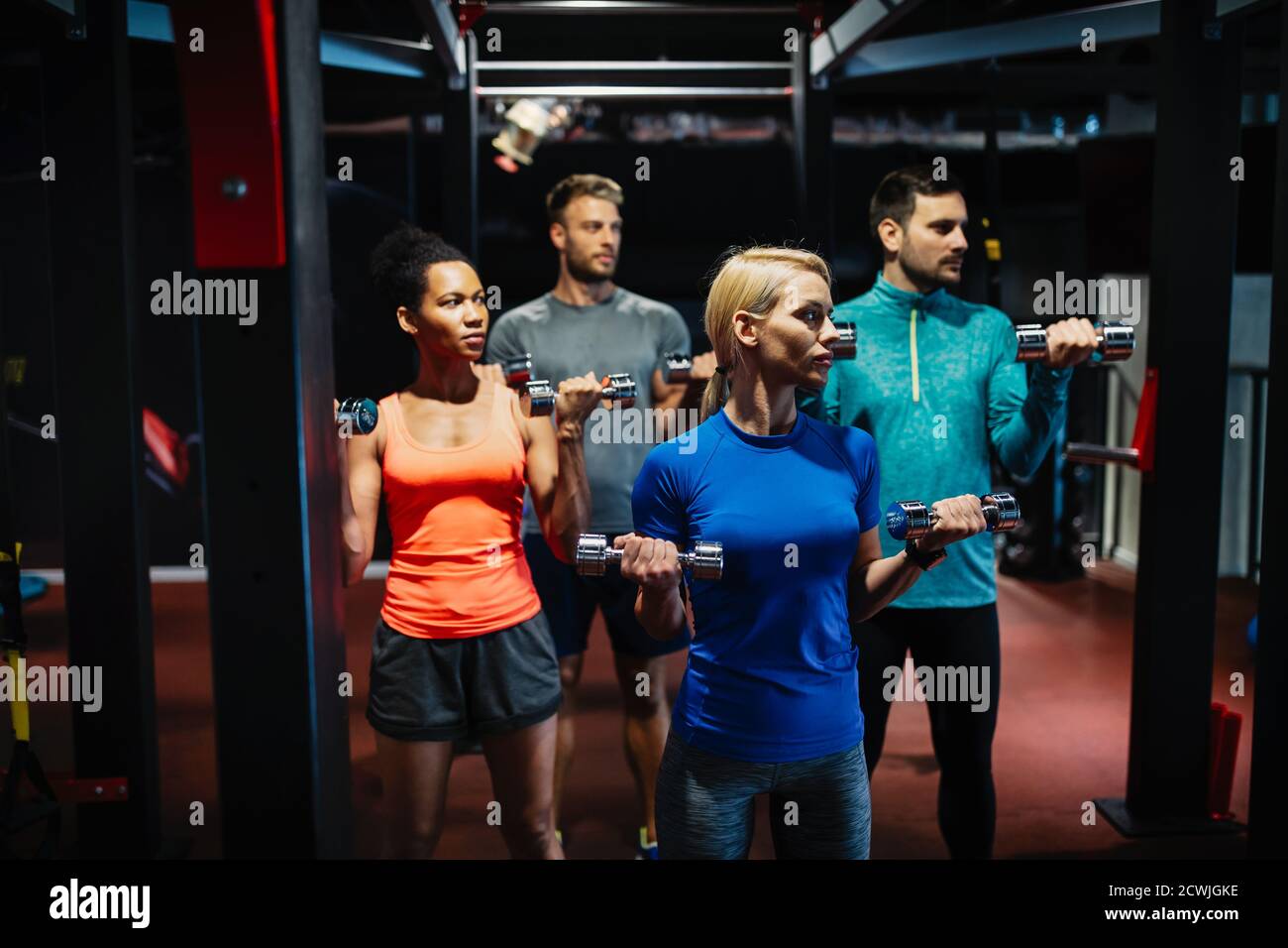 Attractive sports people friends are working out in gym Stock Photo - Alamy