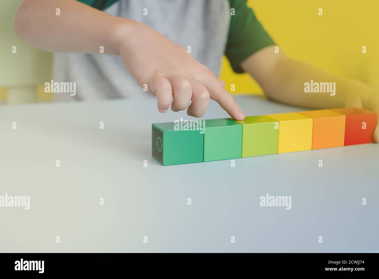 close up of children's hands counting colored blocks in lines on the ...