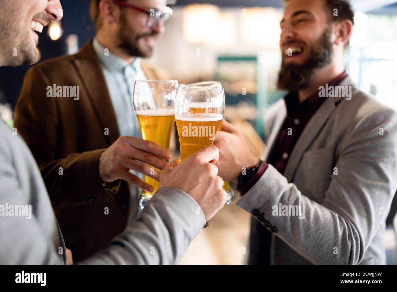 Happy young business men talking and drinking beer in a pub Stock Photo ...