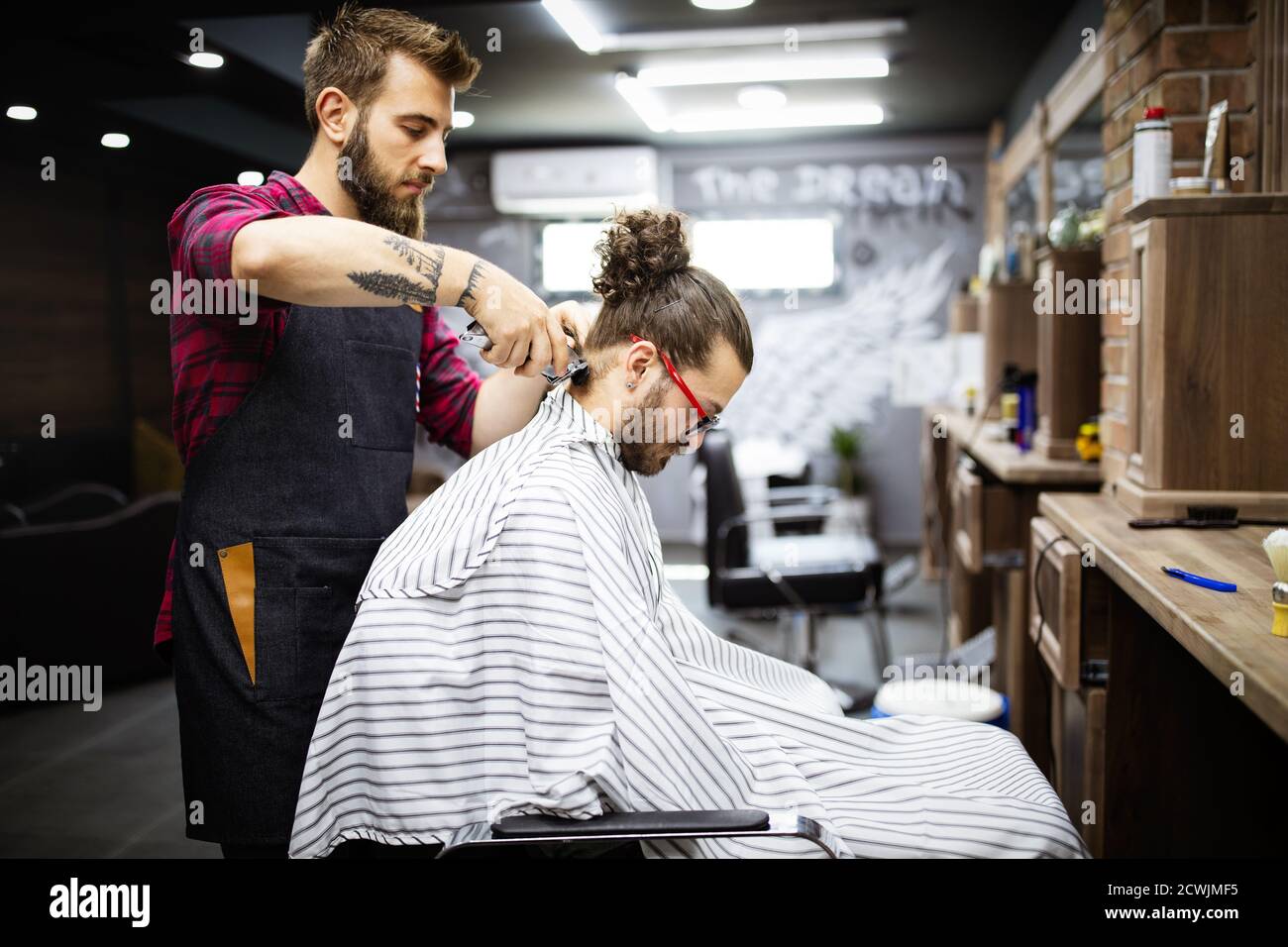 Handsome young man getting haircut in hair salon Stock Photo - Alamy