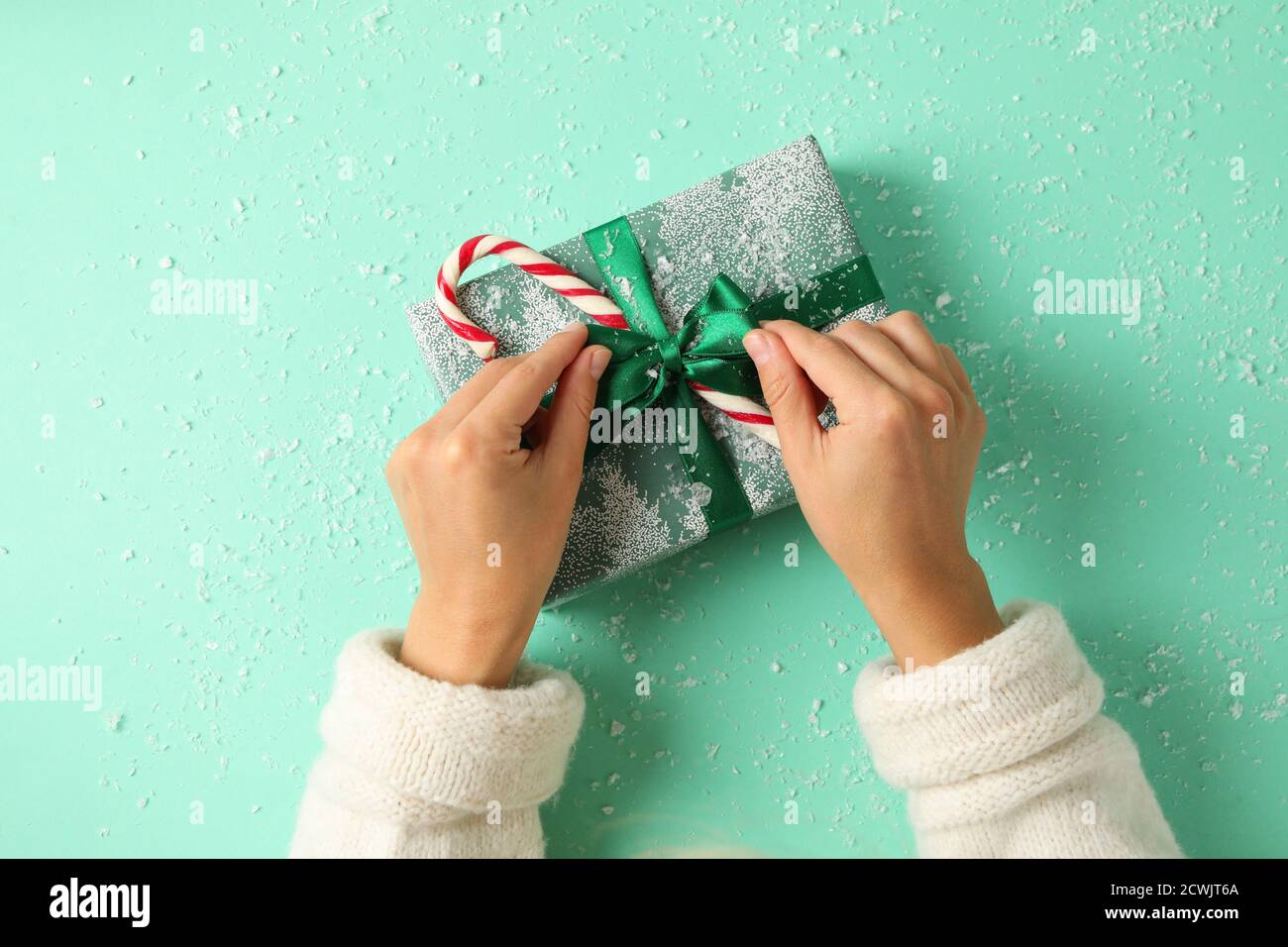 Female hands open the gift box on mint background Stock Photo - Alamy