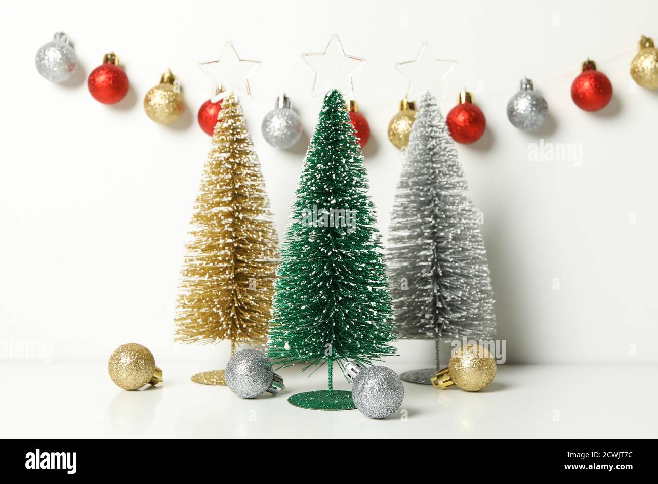 Christmas trees and baubles on white background Stock Photo - Alamy