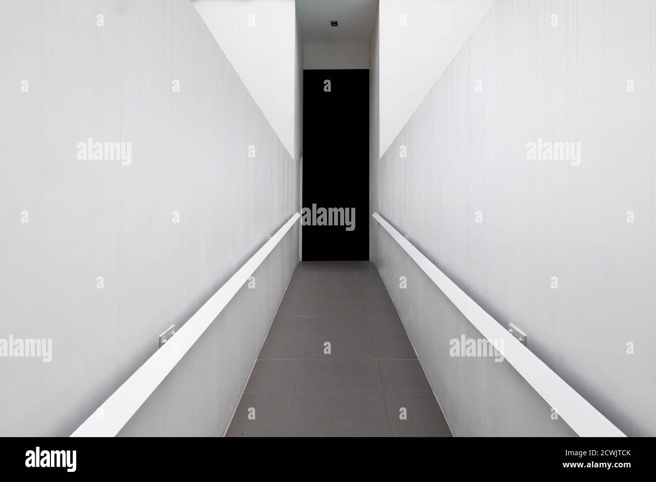 Concrete corridor with white wall and granite tile to black door Stock ...