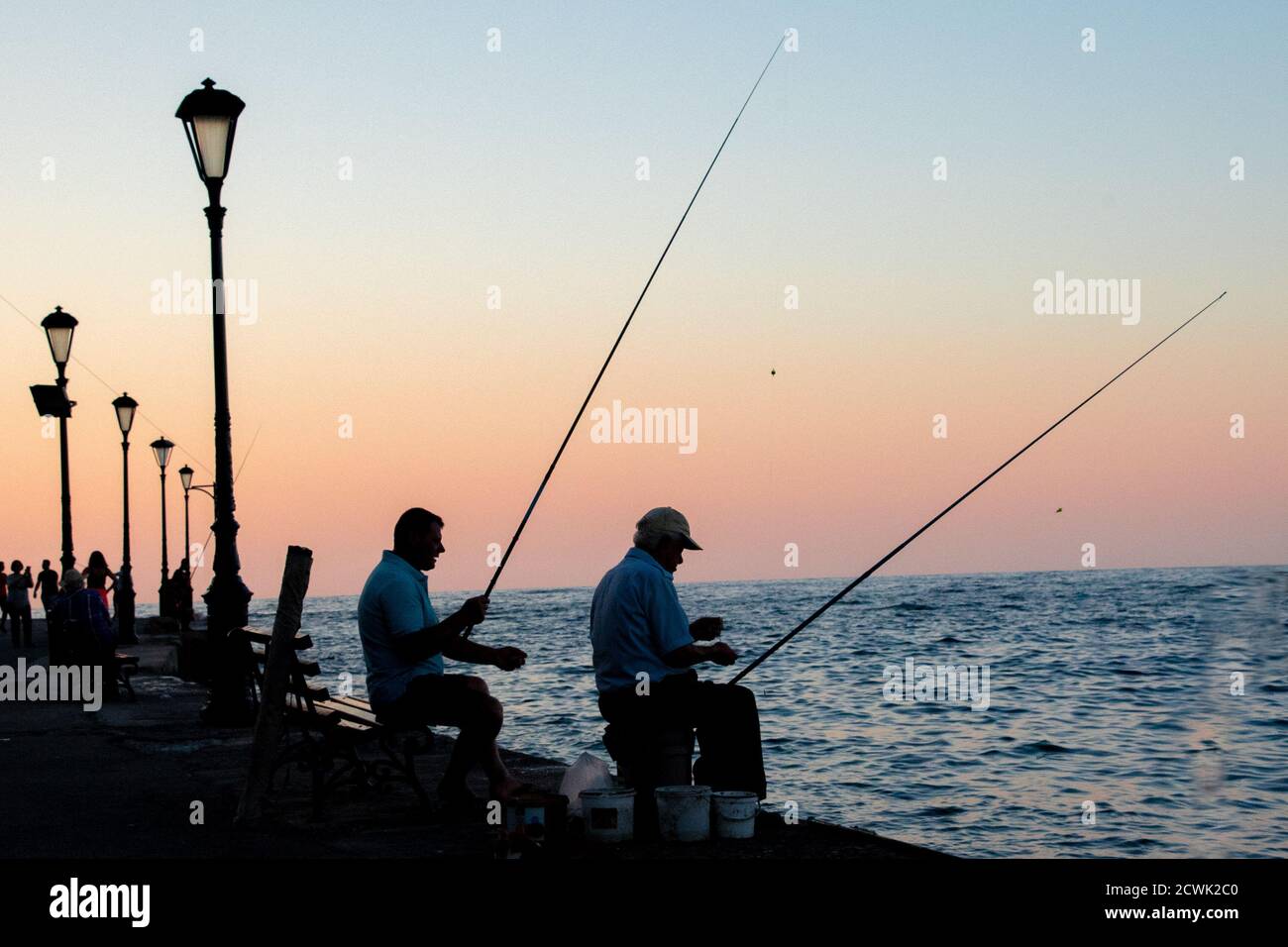 Greek fishermen in the sunset Stock Photo - Alamy