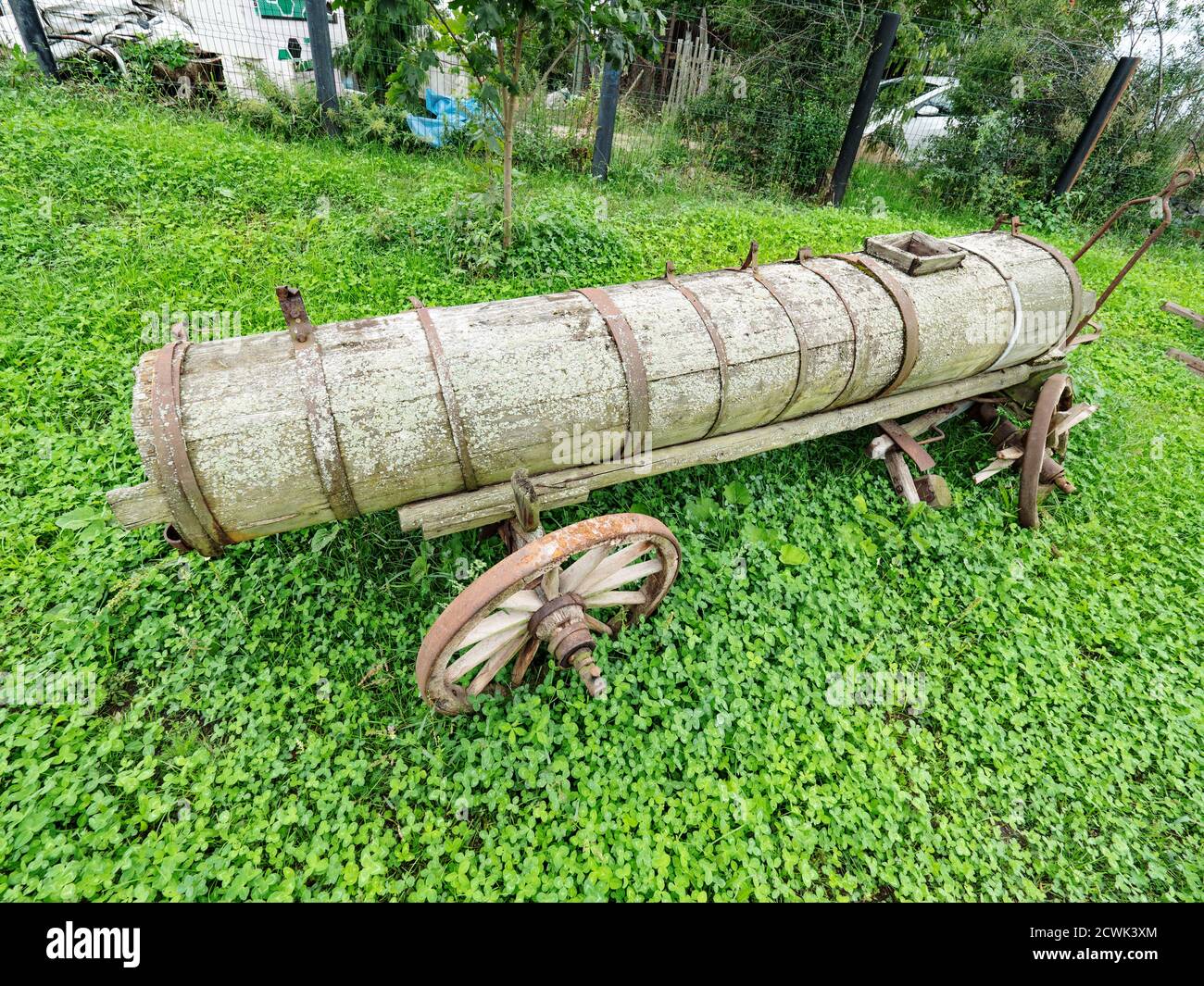 The wooden antiquated horse drawn water cart in a rural area during the ...