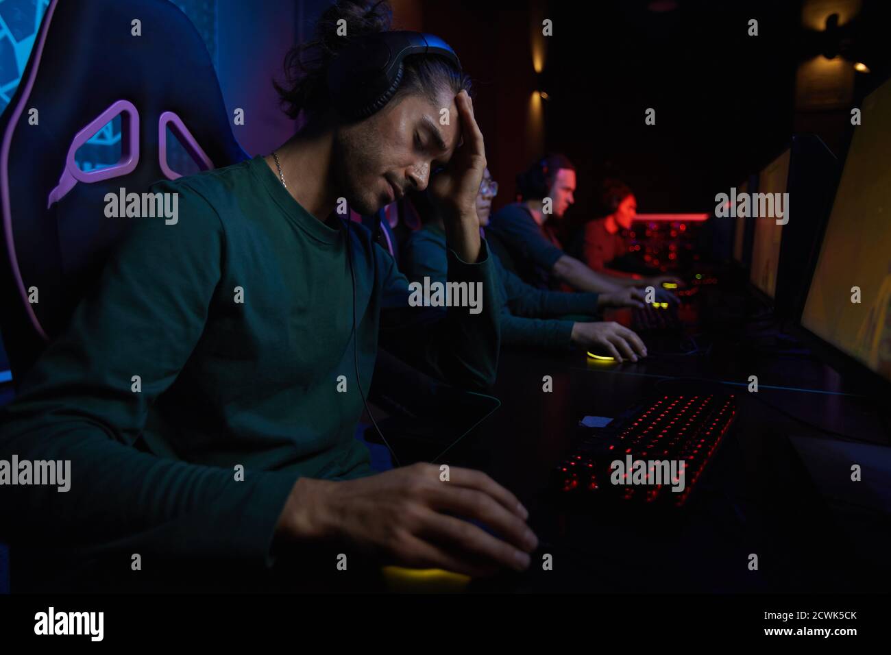 Young computer programmer sitting at his workplace in front of computer ...