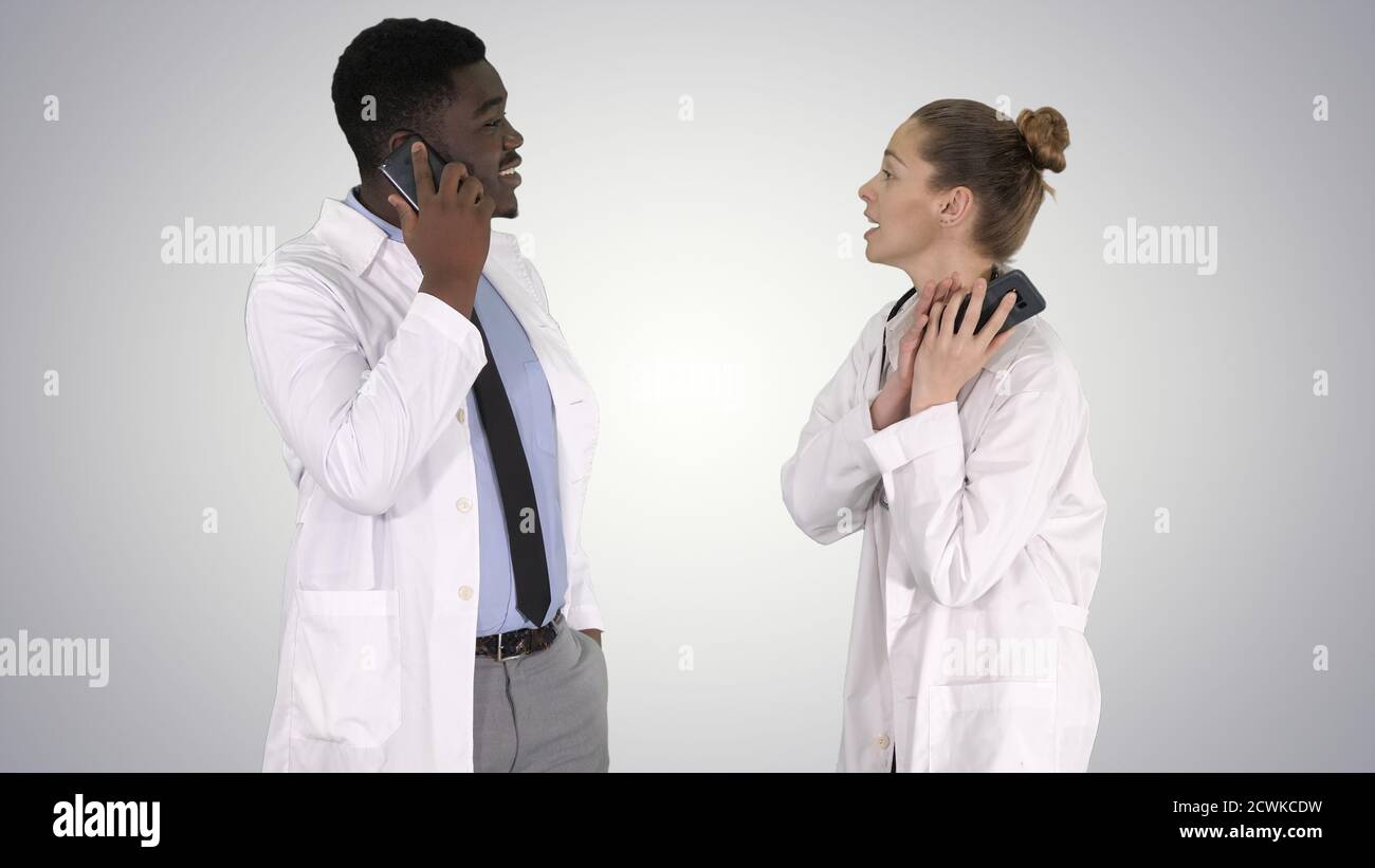 Female and male doctor using mobile phones making calls telling Stock ...