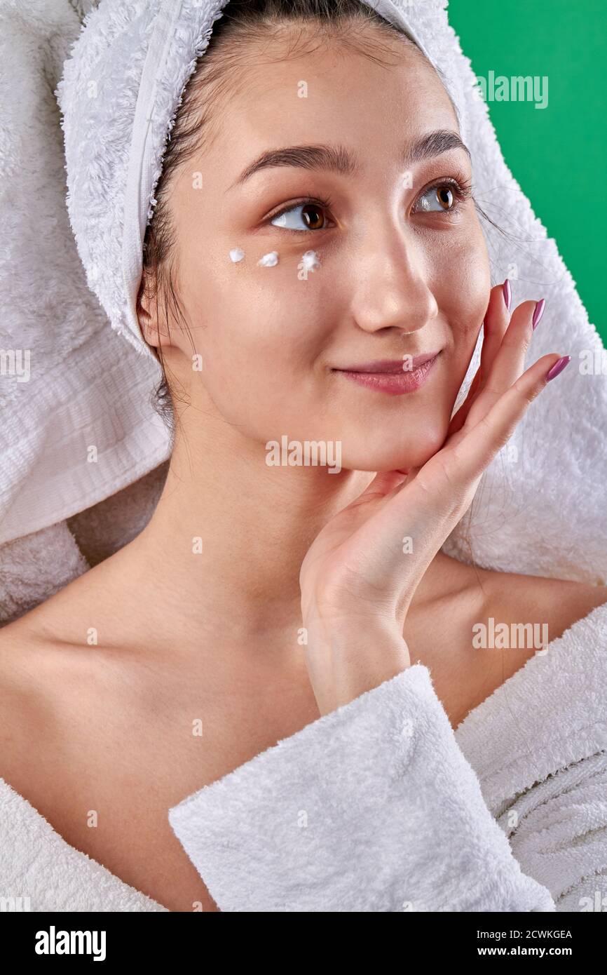Young woman applying cream dots on her face Stock Photo - Alamy