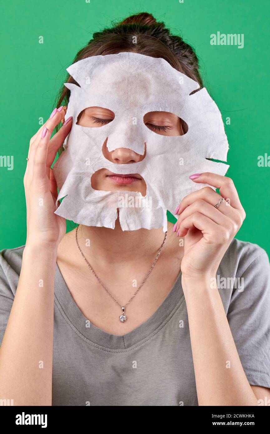 Portrait of girl applying paper spa mask Stock Photo - Alamy