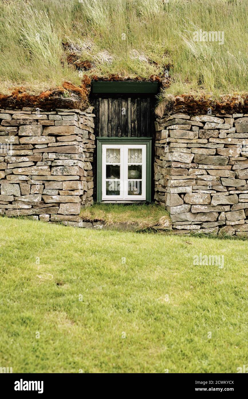 Traditional Icelandic turf roof and stone walled house with window in ...