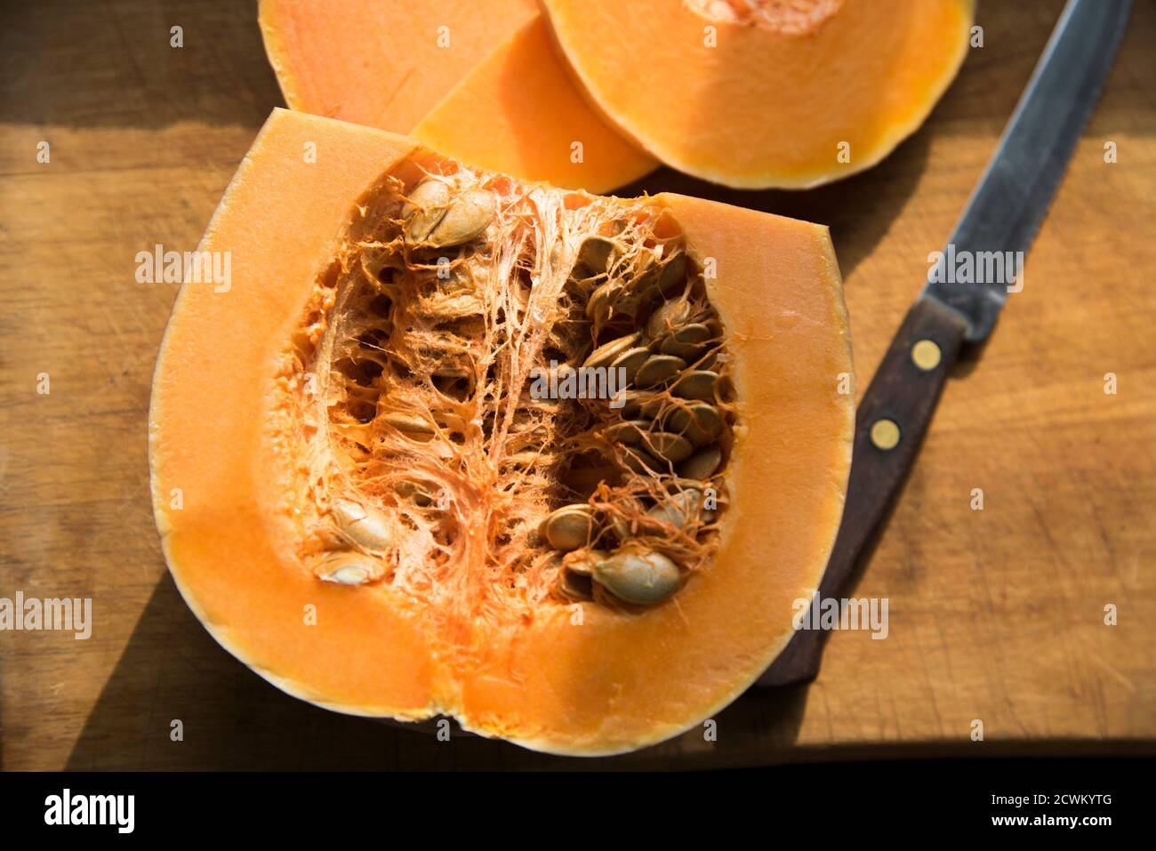 Half of the fresh pumpkin and slices of pumpkin on the table Stock ...