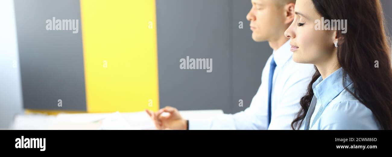 Employees in office sit at table and meditate closeup Stock Photo - Alamy
