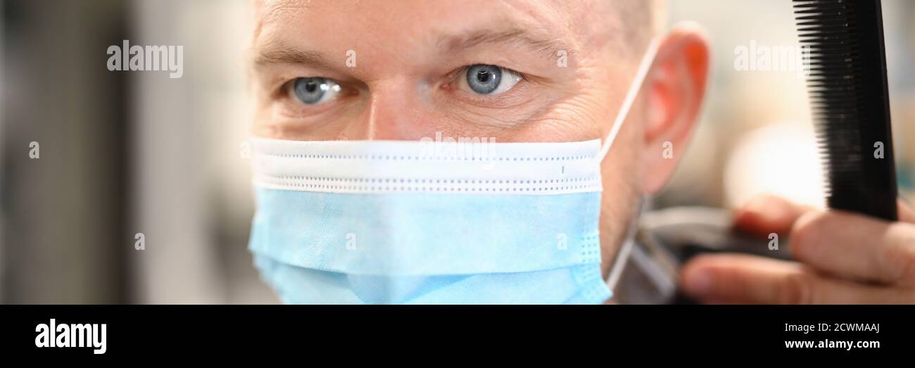 Man in medical mask has haircut in hairdressing salon Stock Photo - Alamy