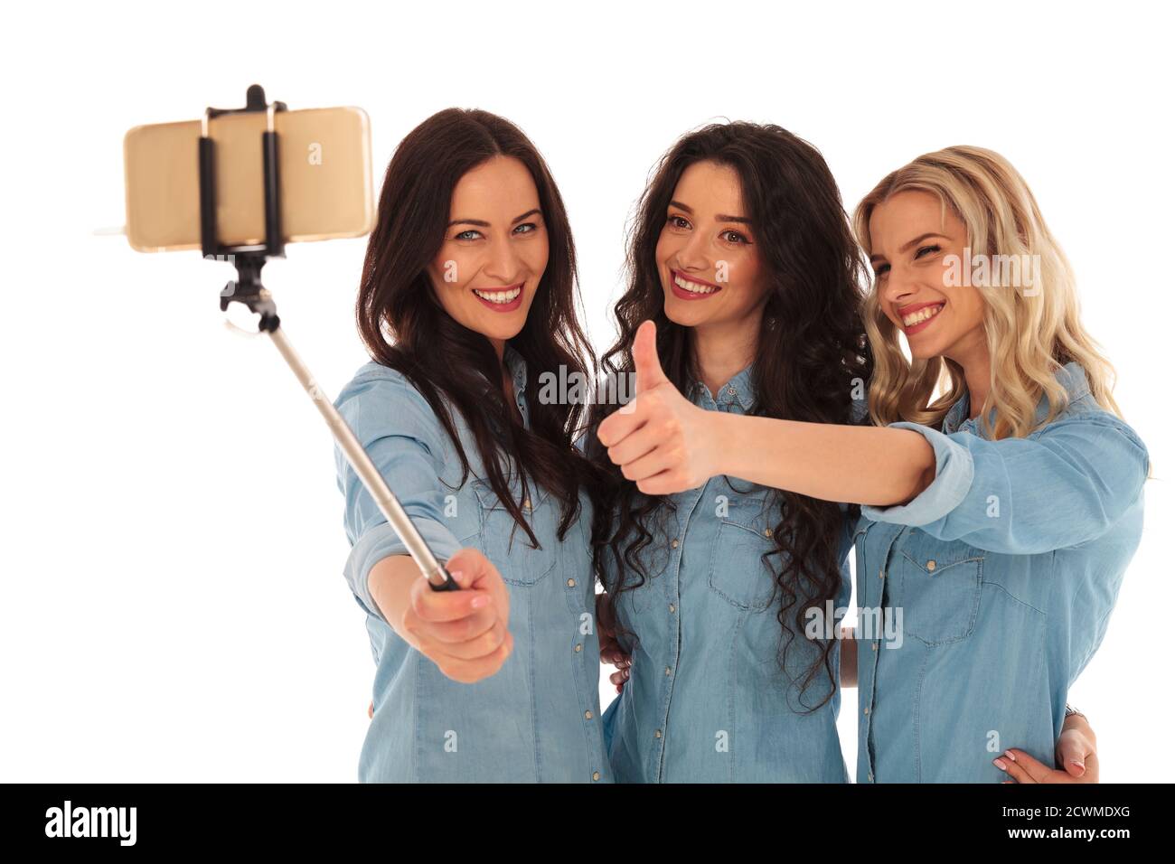 3 smiling casual women taking a selfie and making the ok thumbs up sign ...