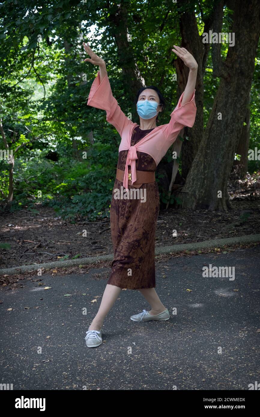 Surrounded by trees and foliage, an elegant Chinese American dancer ...