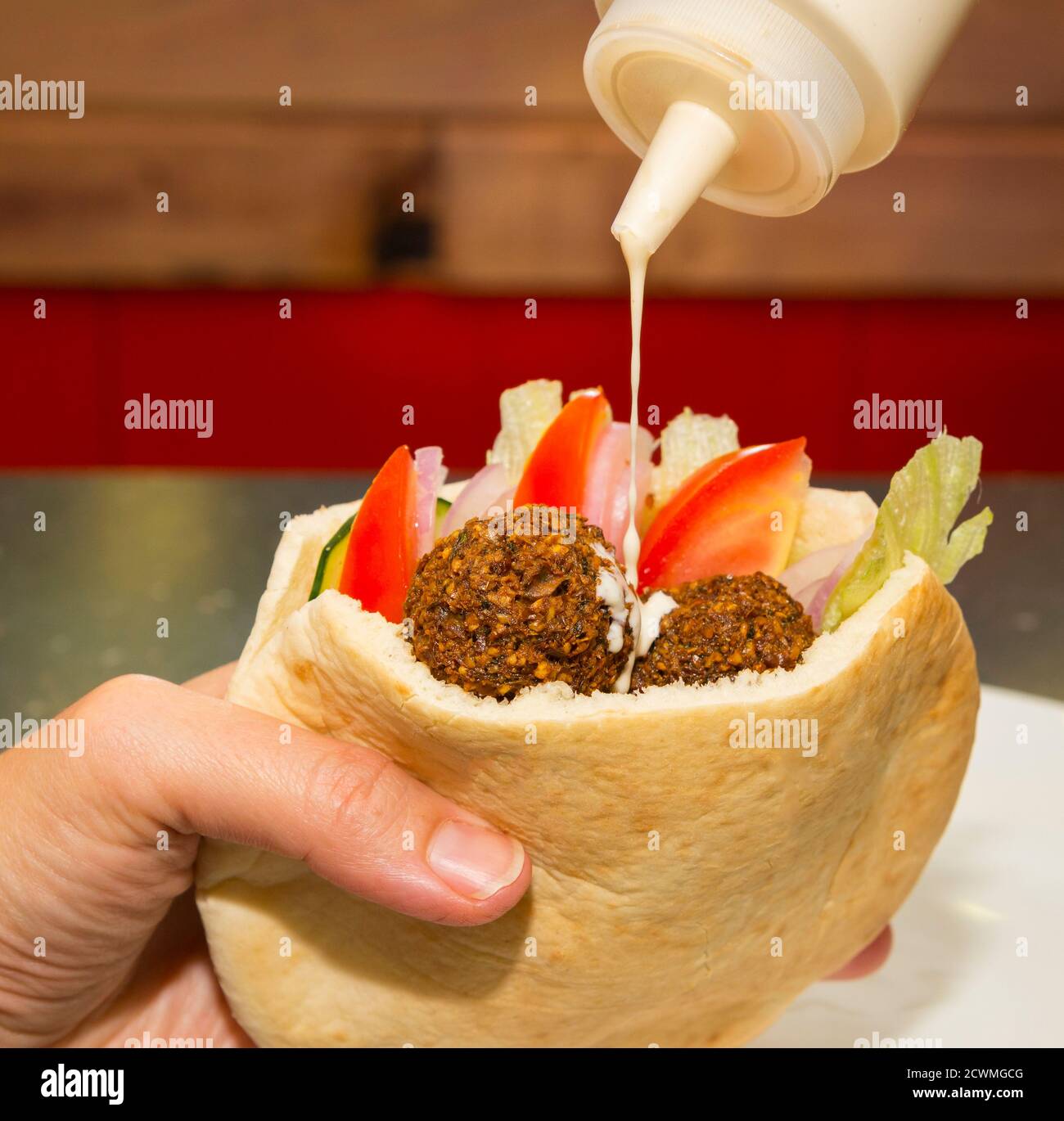 Pita bread filled with falafel, vegetable salad and tahina sauce Stock ...